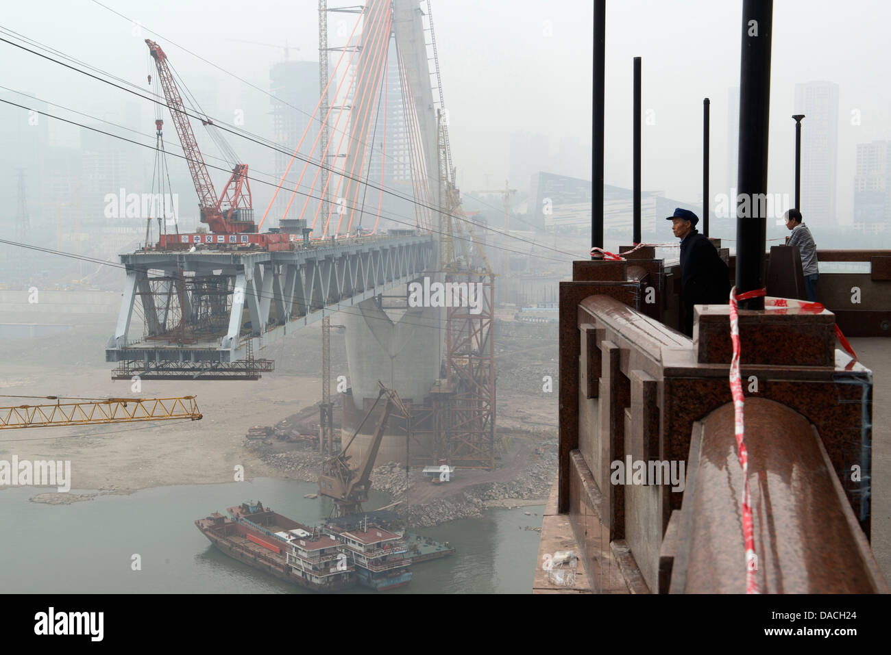 People look at the Qiansimen Bridge under construction over the Jialing ...