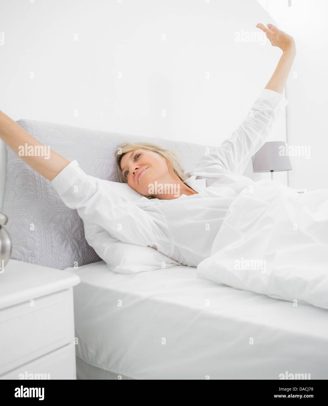 Blonde woman waking up and stetching Stock Photo - Alamy