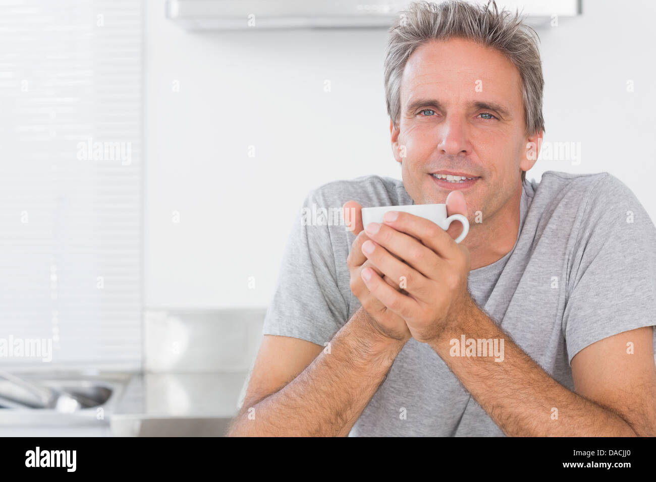 Happy man having coffee in kitchen Stock Photo - Alamy