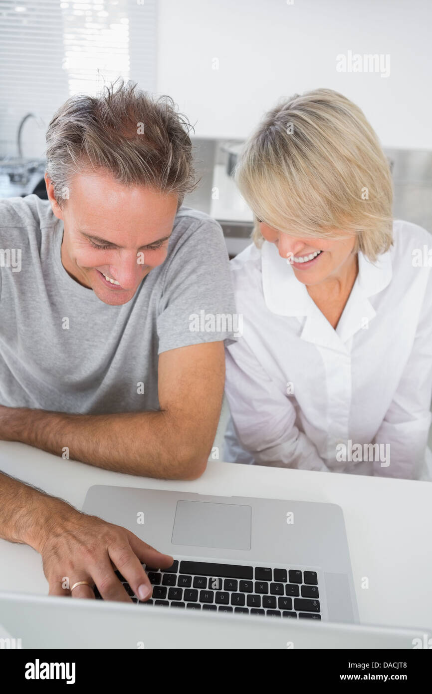 Happy couple using their laptop in the morning Stock Photo - Alamy
