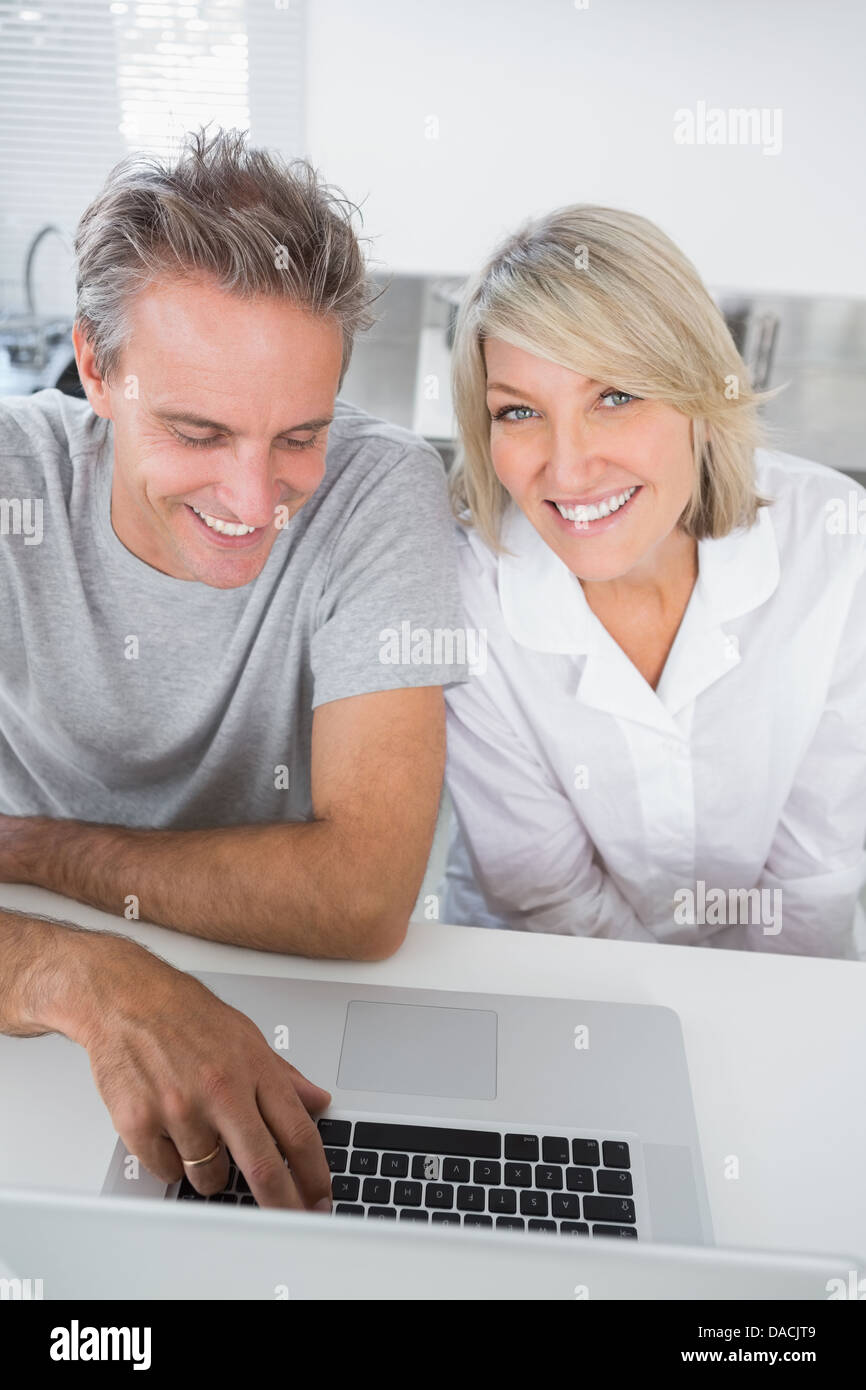 Smiling couple using their laptop in the morning Stock Photo - Alamy
