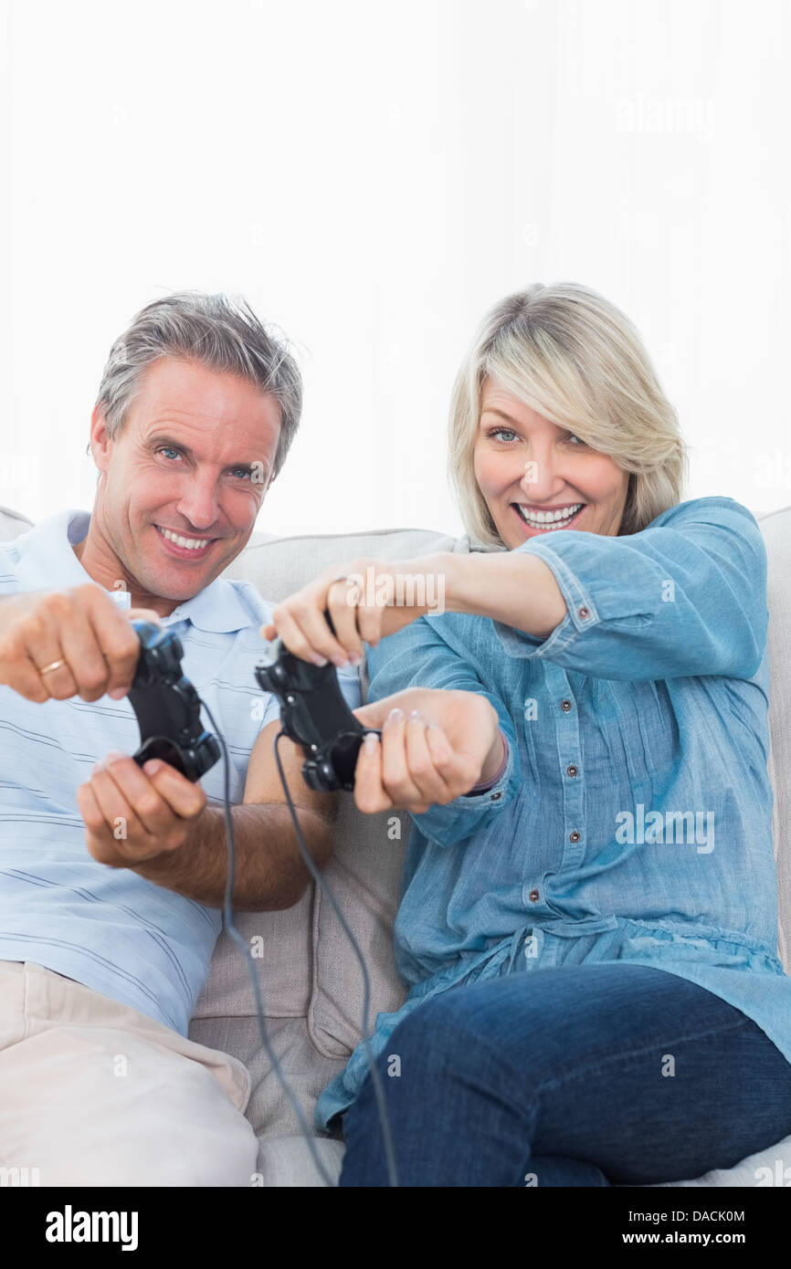 Couple playing video games together on the sofa Stock Photo - Alamy