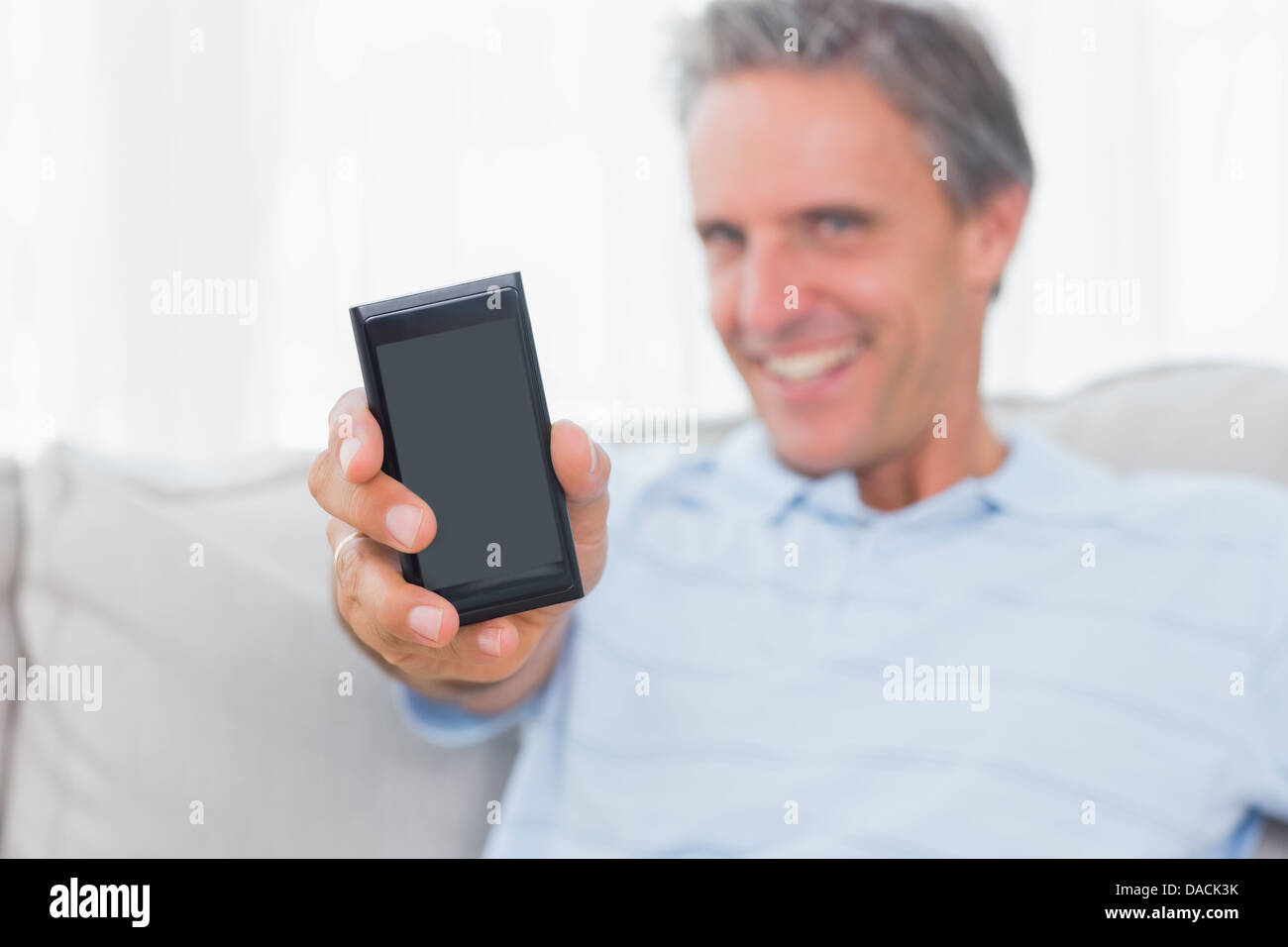 Man showing smartphone to camera Stock Photo - Alamy