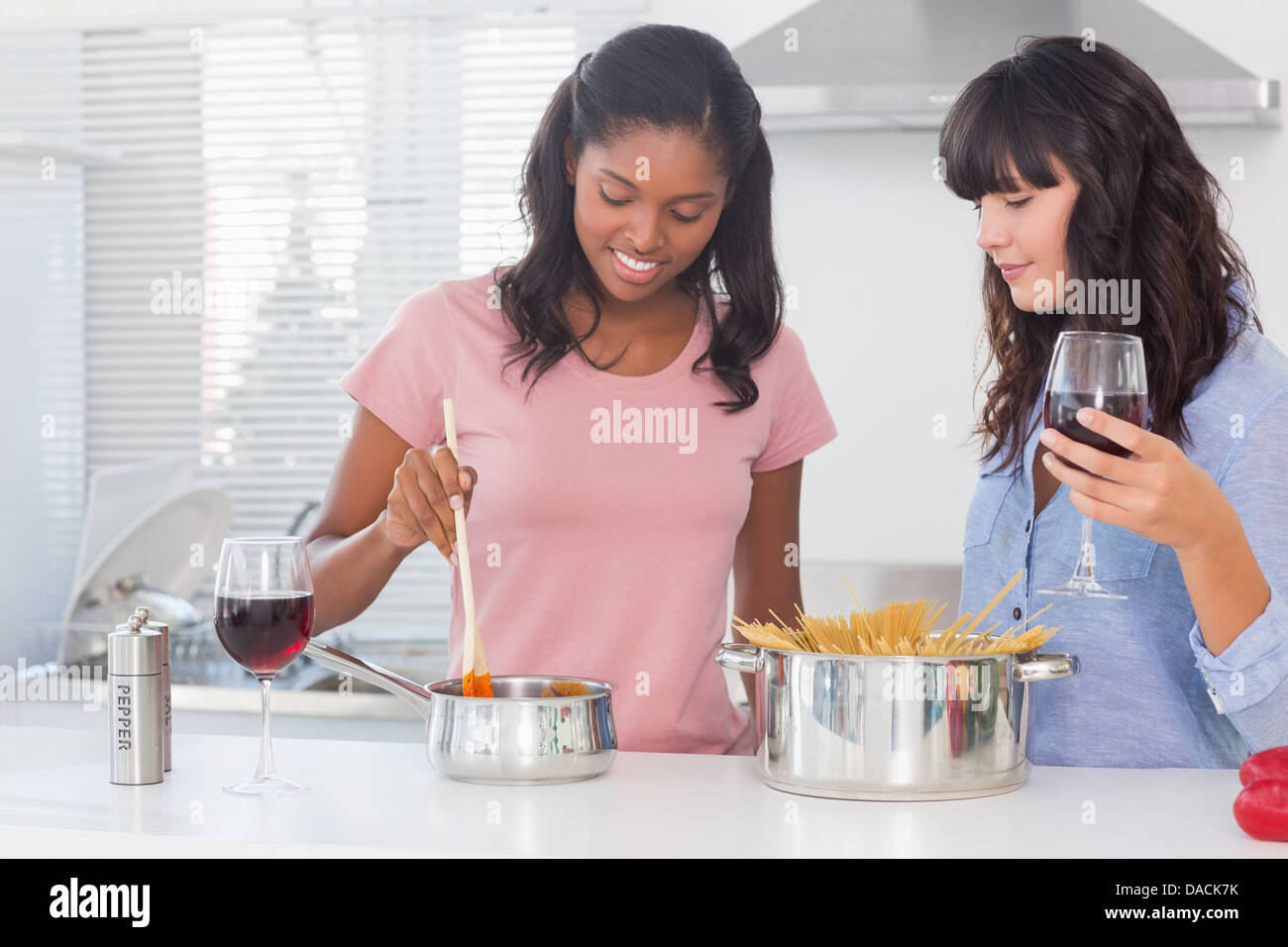 Happy friends making dinner together Stock Photo - Alamy