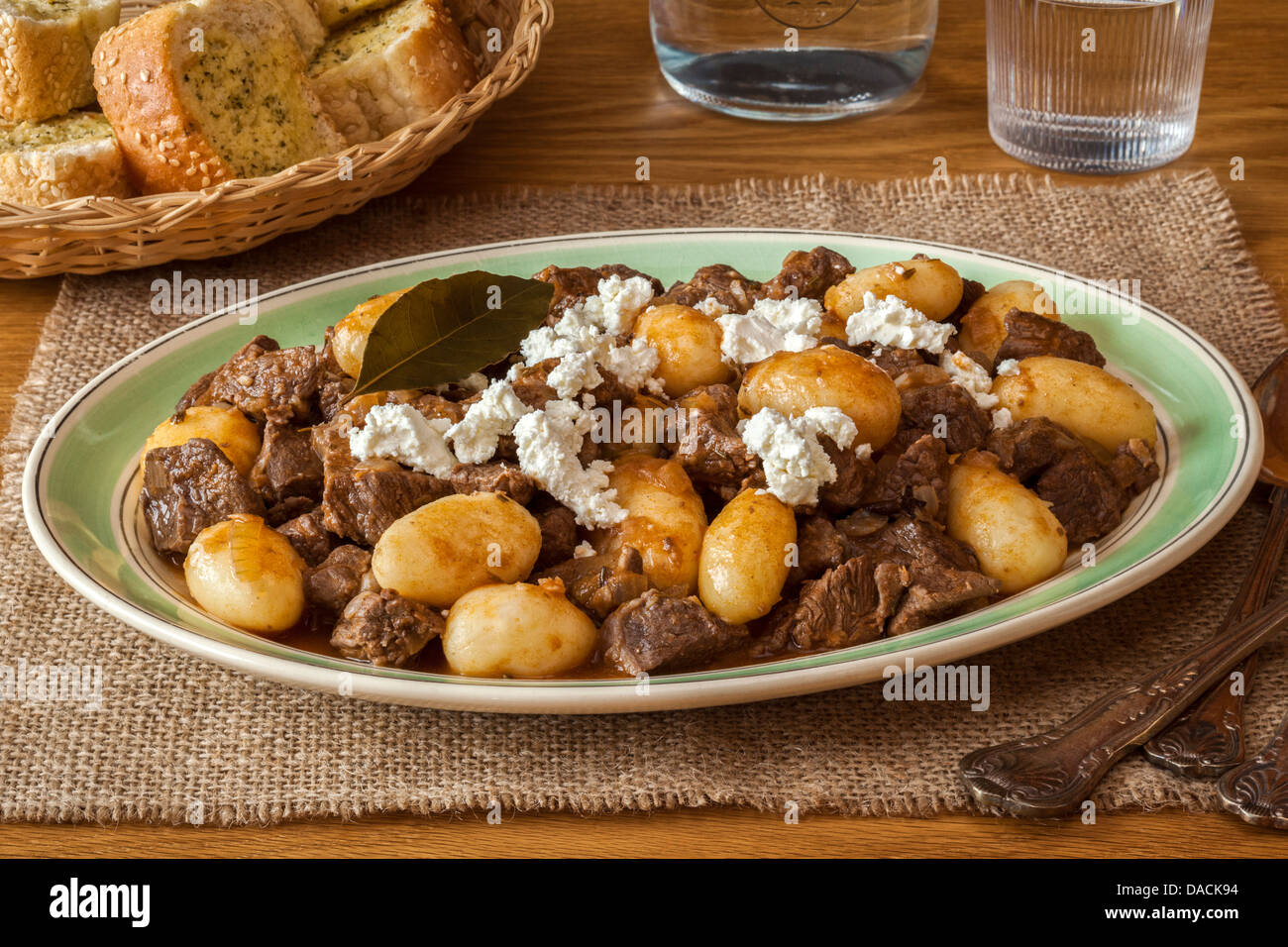 Greek lamb stew, or Stifado, topped with crumbled feta cheese, served ...