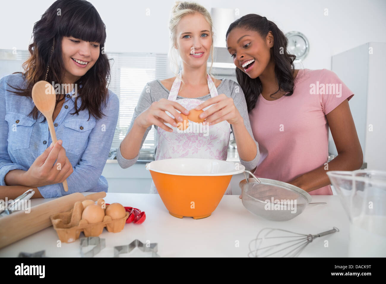 Happy friends making pastry together Stock Photo - Alamy