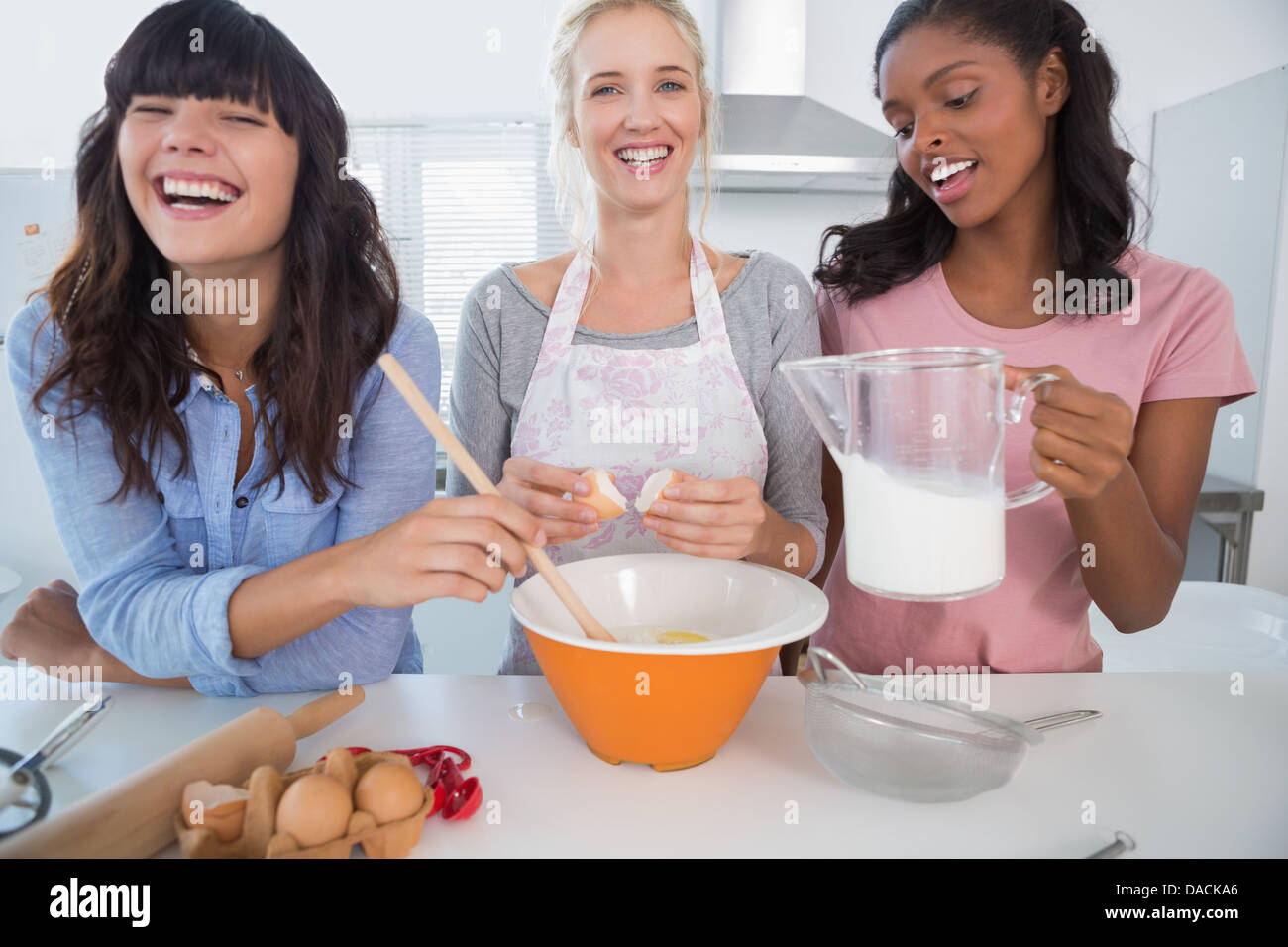 Laughing friends making pastry together Stock Photo - Alamy