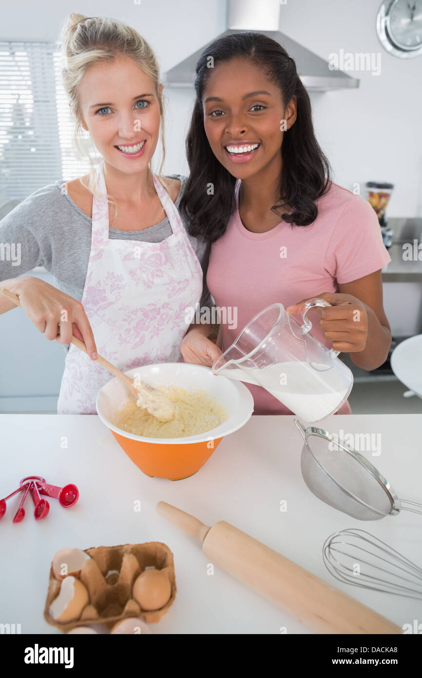 Pretty friends making pastry together looking at camera Stock Photo - Alamy