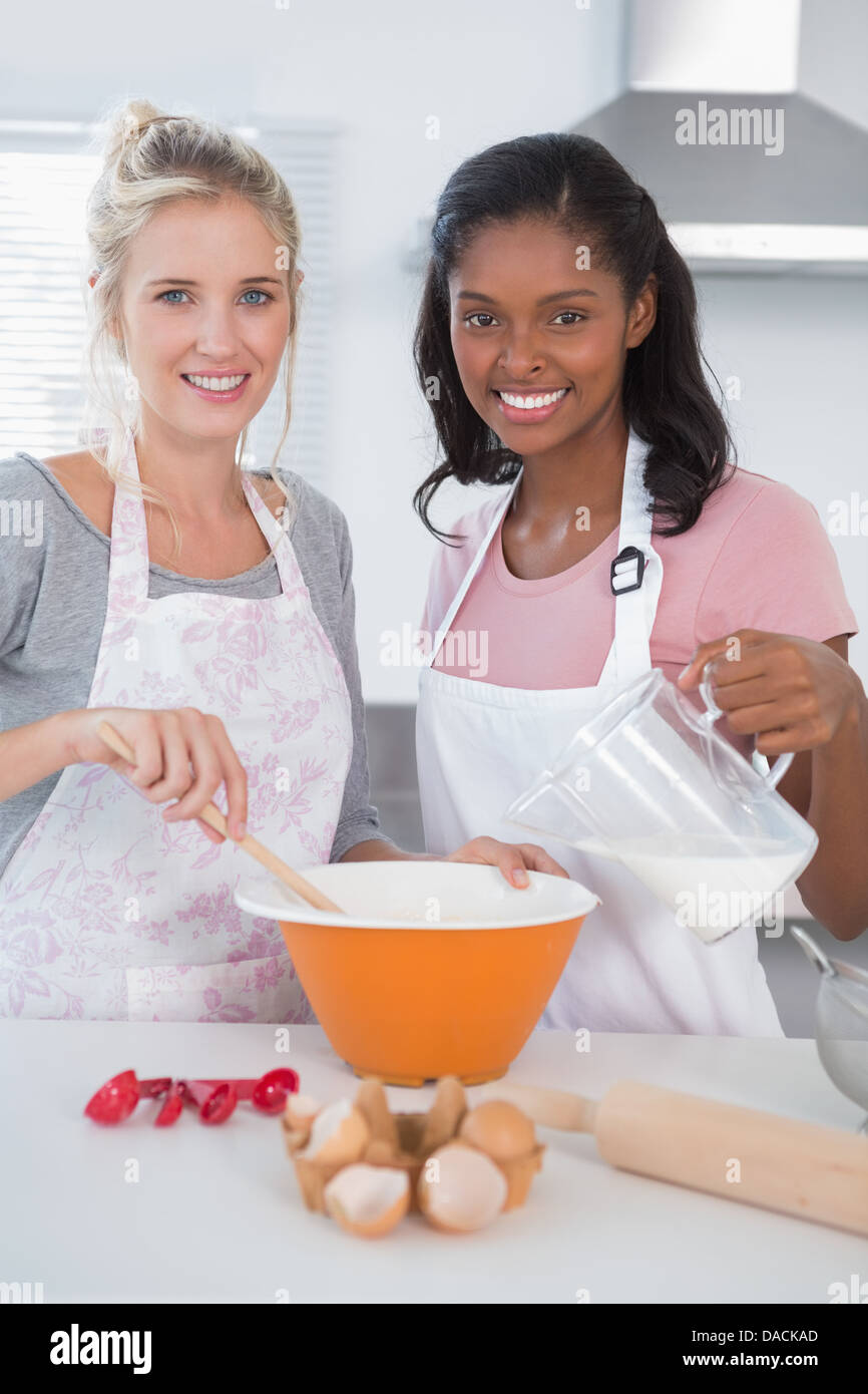 Smiling friends making dough together looking at camera Stock Photo - Alamy