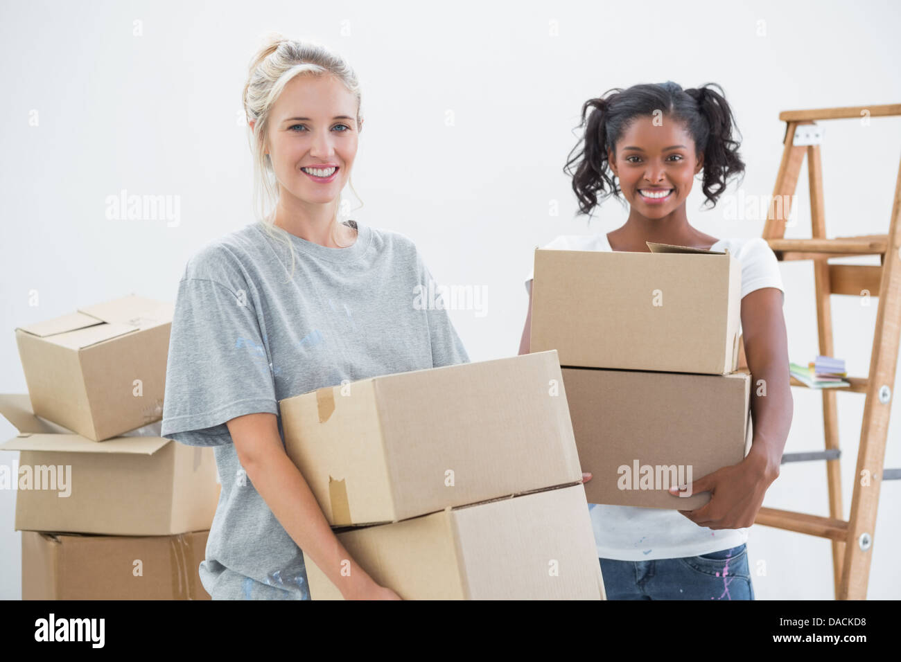Cheerful housemates carrying moving boxes Stock Photo - Alamy