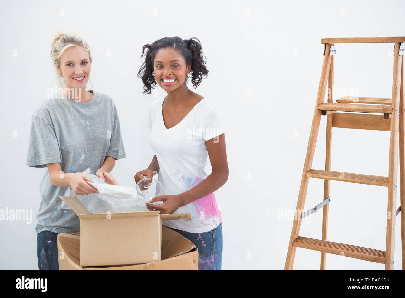 Happy housemates unpacking moving boxes Stock Photo - Alamy