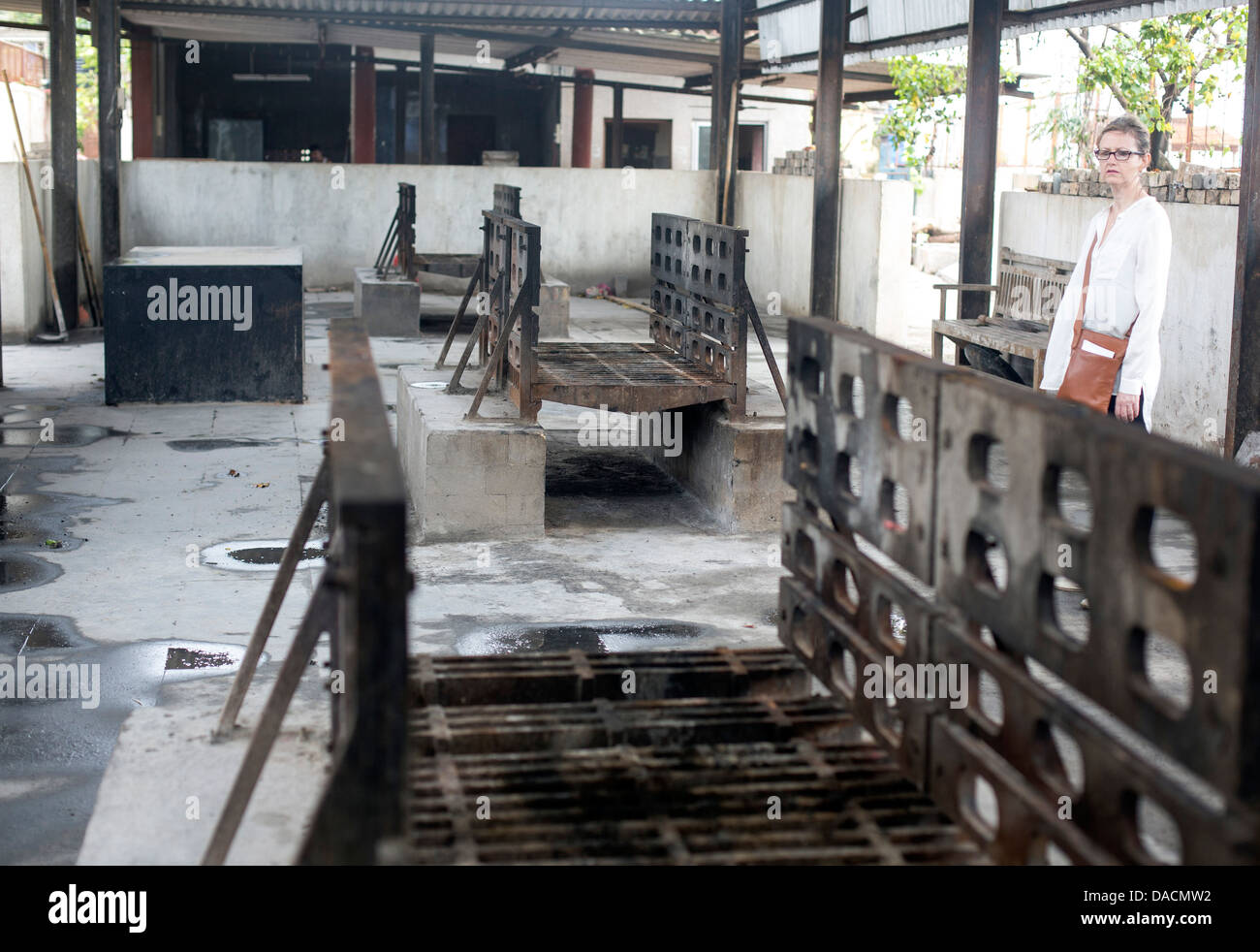 Woman looking a indian crematorium next to slum Stock Photo - Alamy