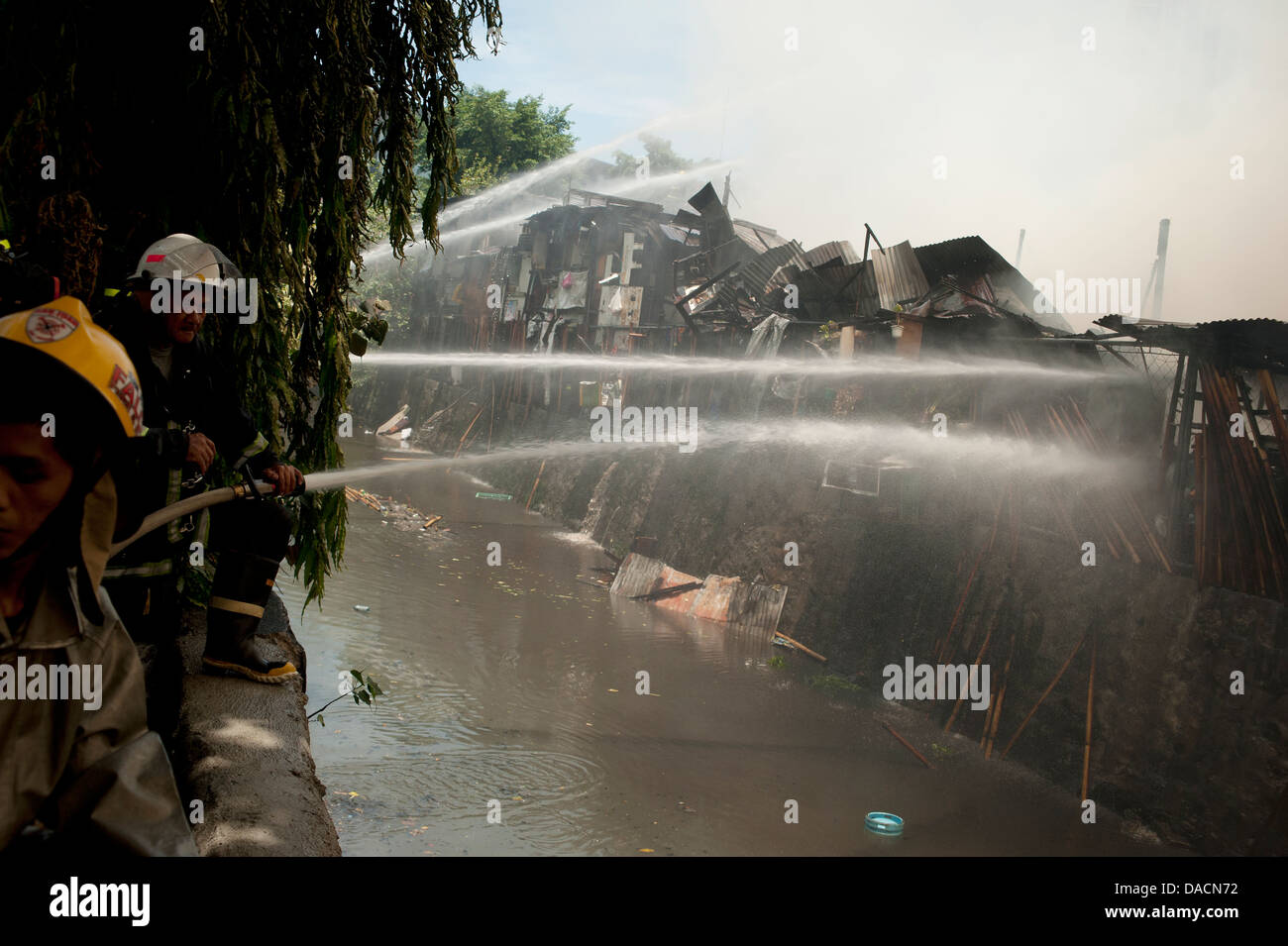 Firemen hose down a fire in a shanty town in Makati City, Metro Manila ...