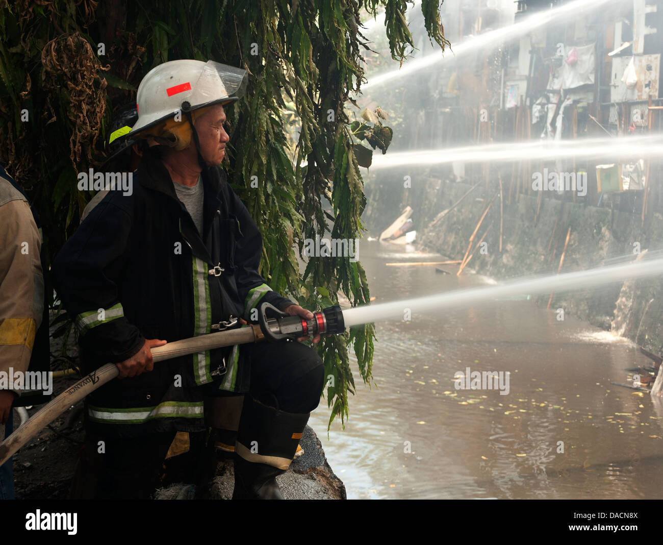 Firemen hose down a fire in a shanty town in Makati City, Metro Manila ...