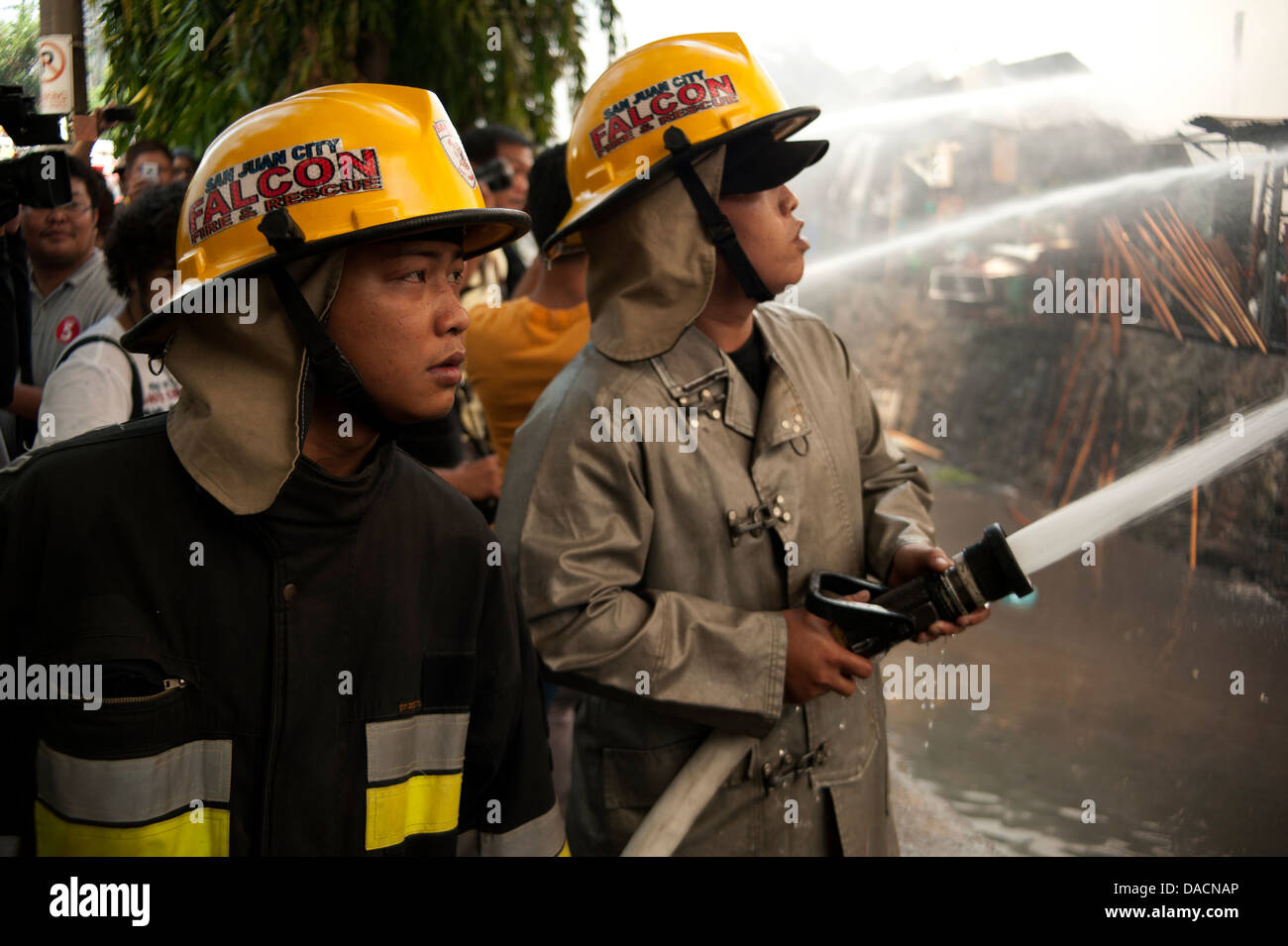 Firemen hose down a fire in a shanty town in Makati City, Metro Manila ...