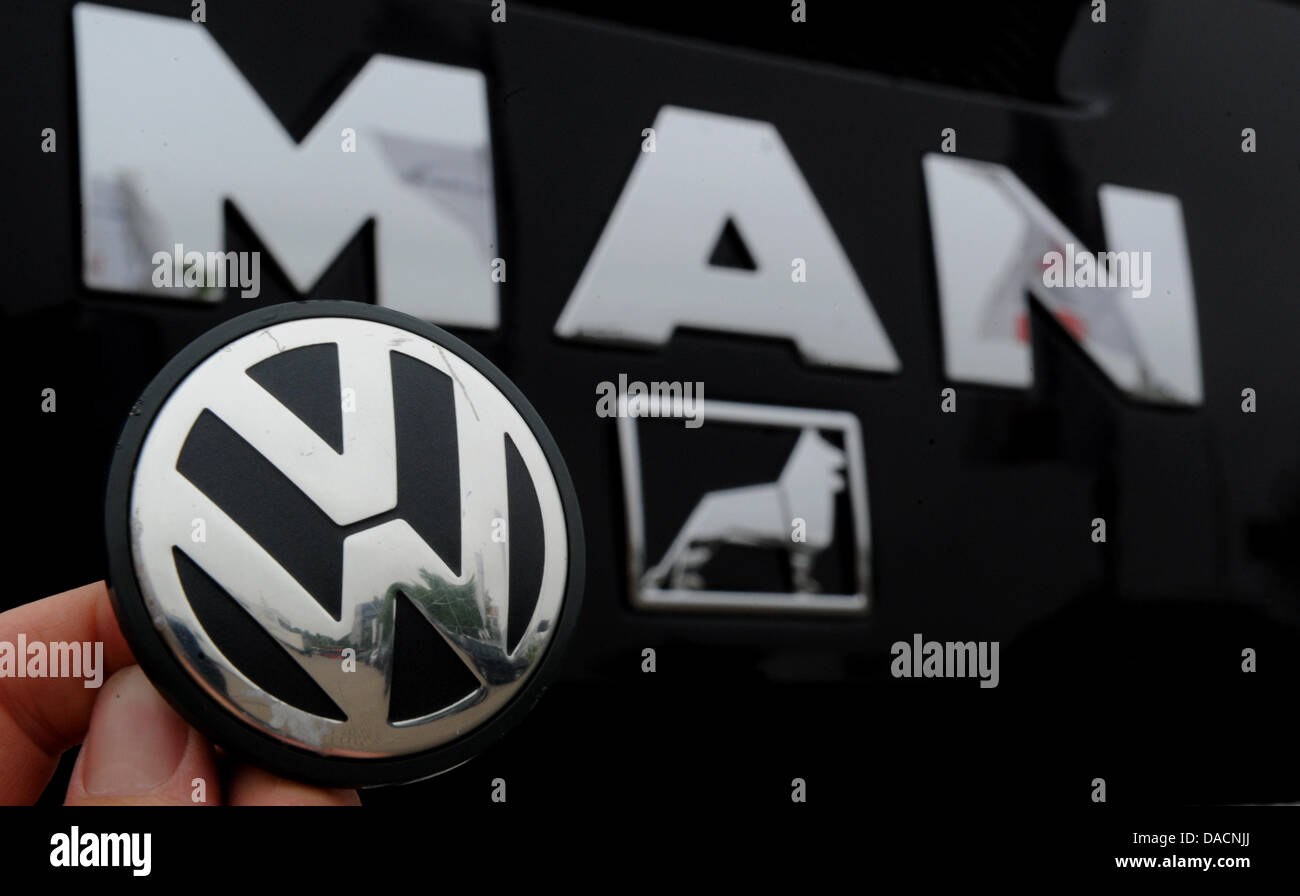 The Volkswagen logo is held next to the MAN logo in Hanover, Germany, 4 ...