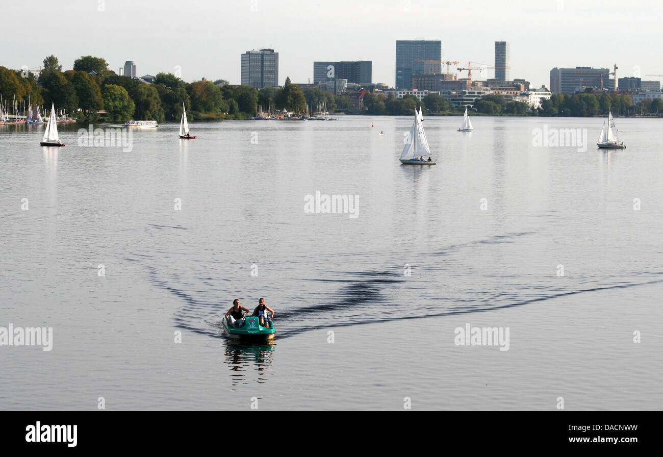 Two yound women travel across Outer Alster Lake in a pedal boat in ...