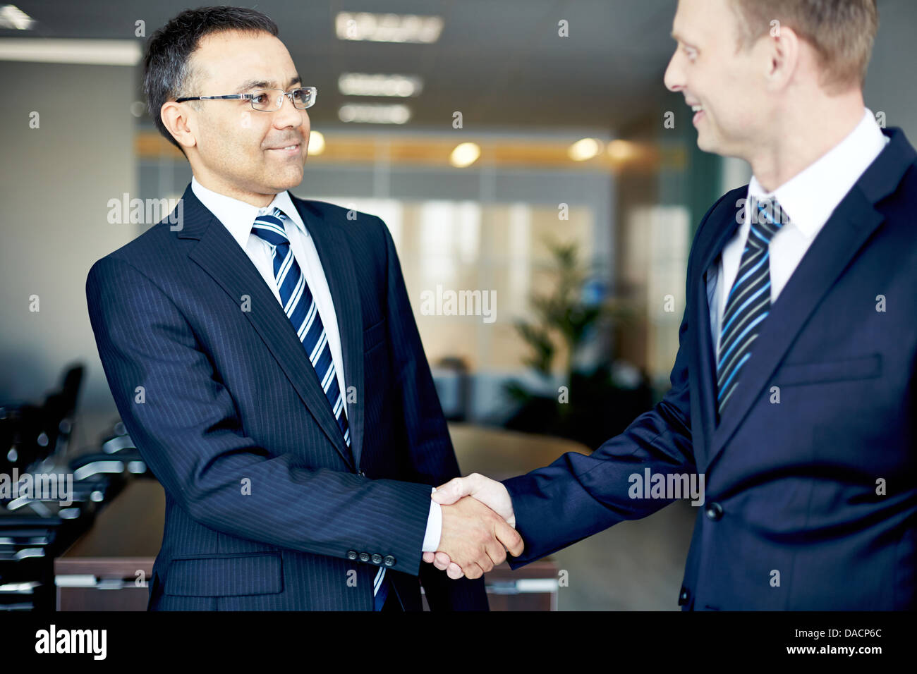 Portrait of elegant businessmen handshaking in conference hall Stock ...