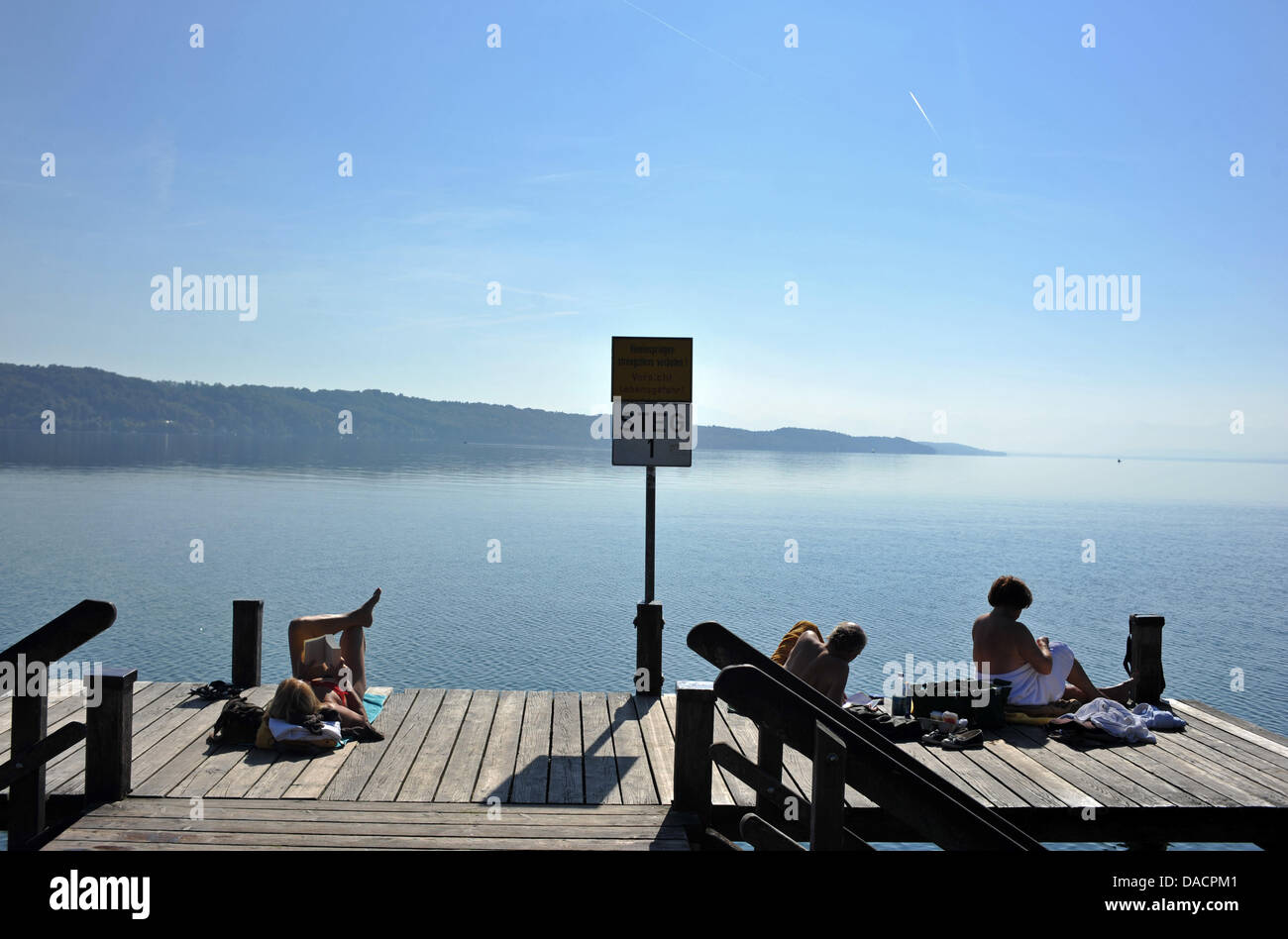 People sunbath on a dock on Lake Starnberg in Poecking, Germany, 30 ...