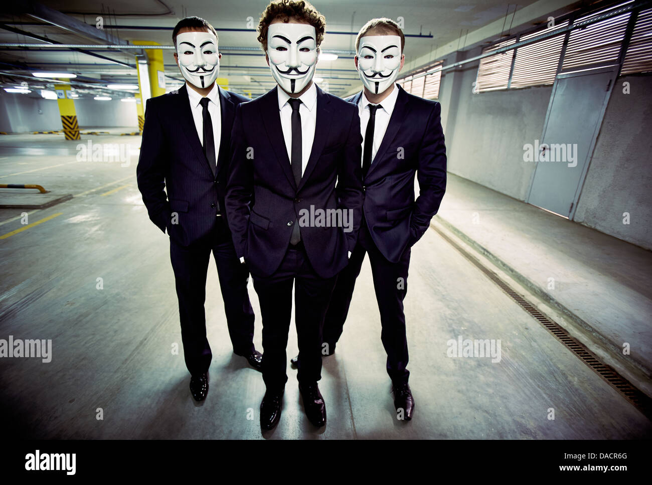 Portrait of anonymous masked businessmen standing in an empty ...