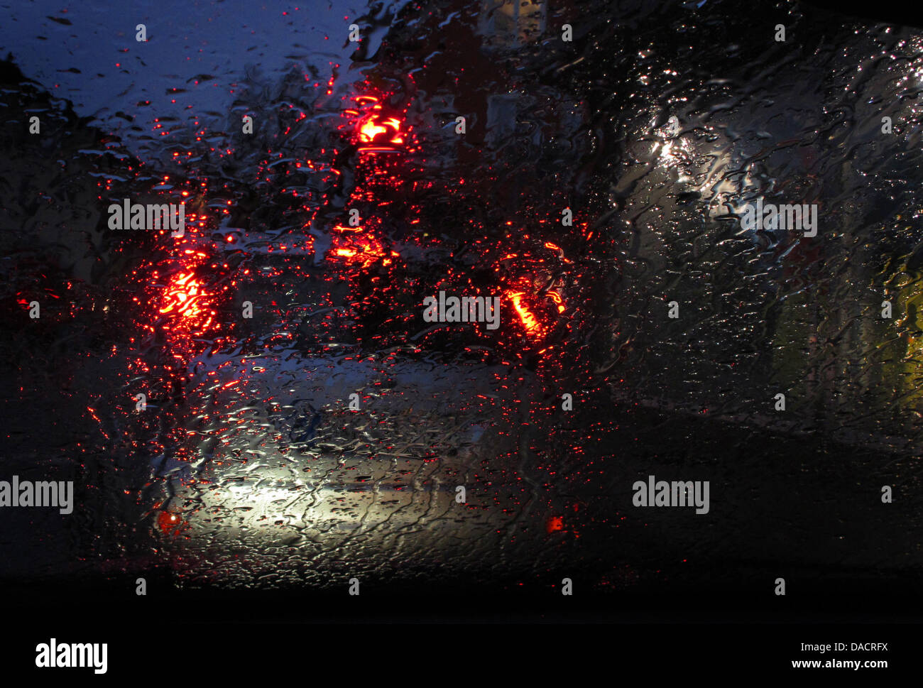 The rain blurs the light of cars, street lights and traffic lights near ...