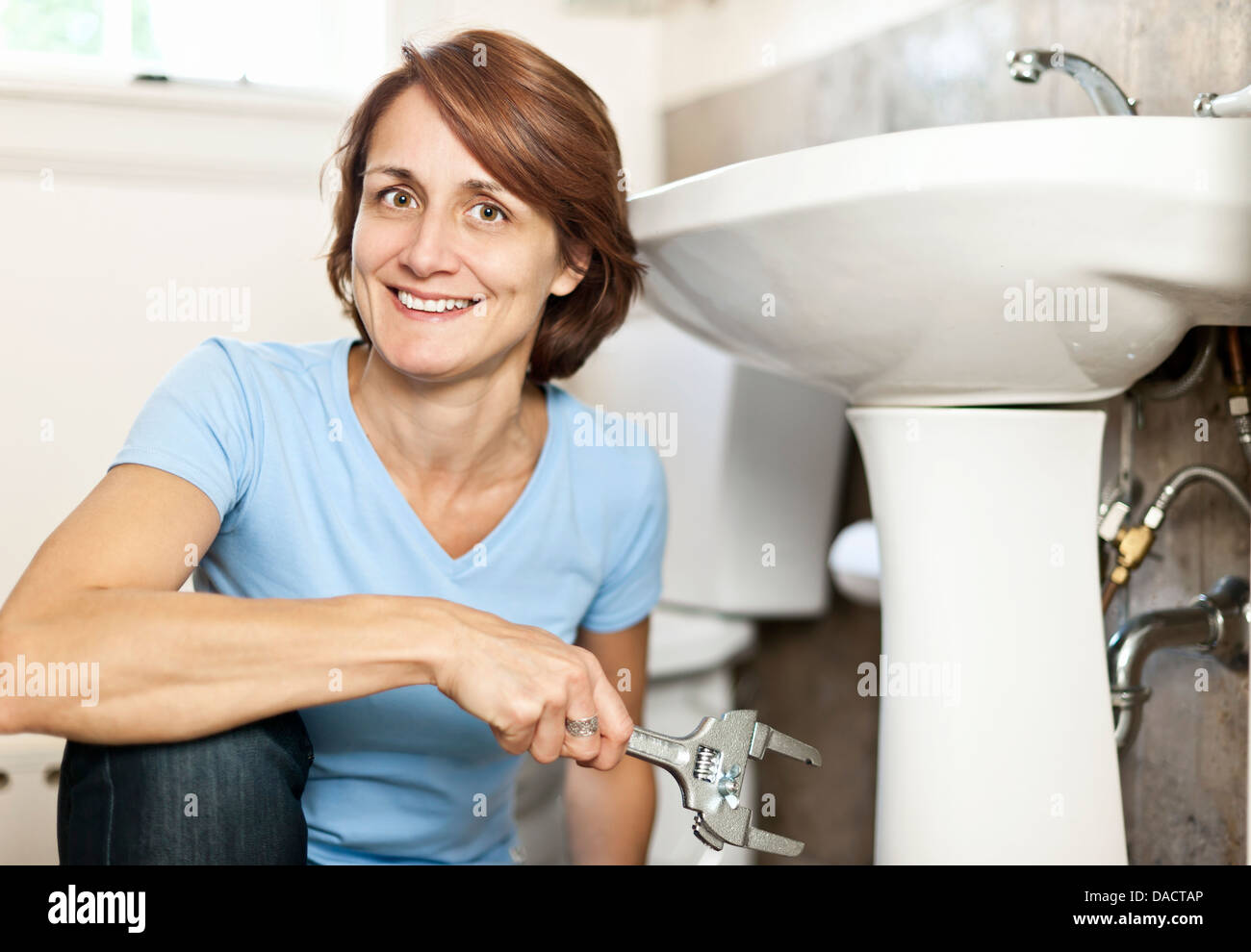 Confident woman repairing sink in bathroom at home Stock Photo - Alamy
