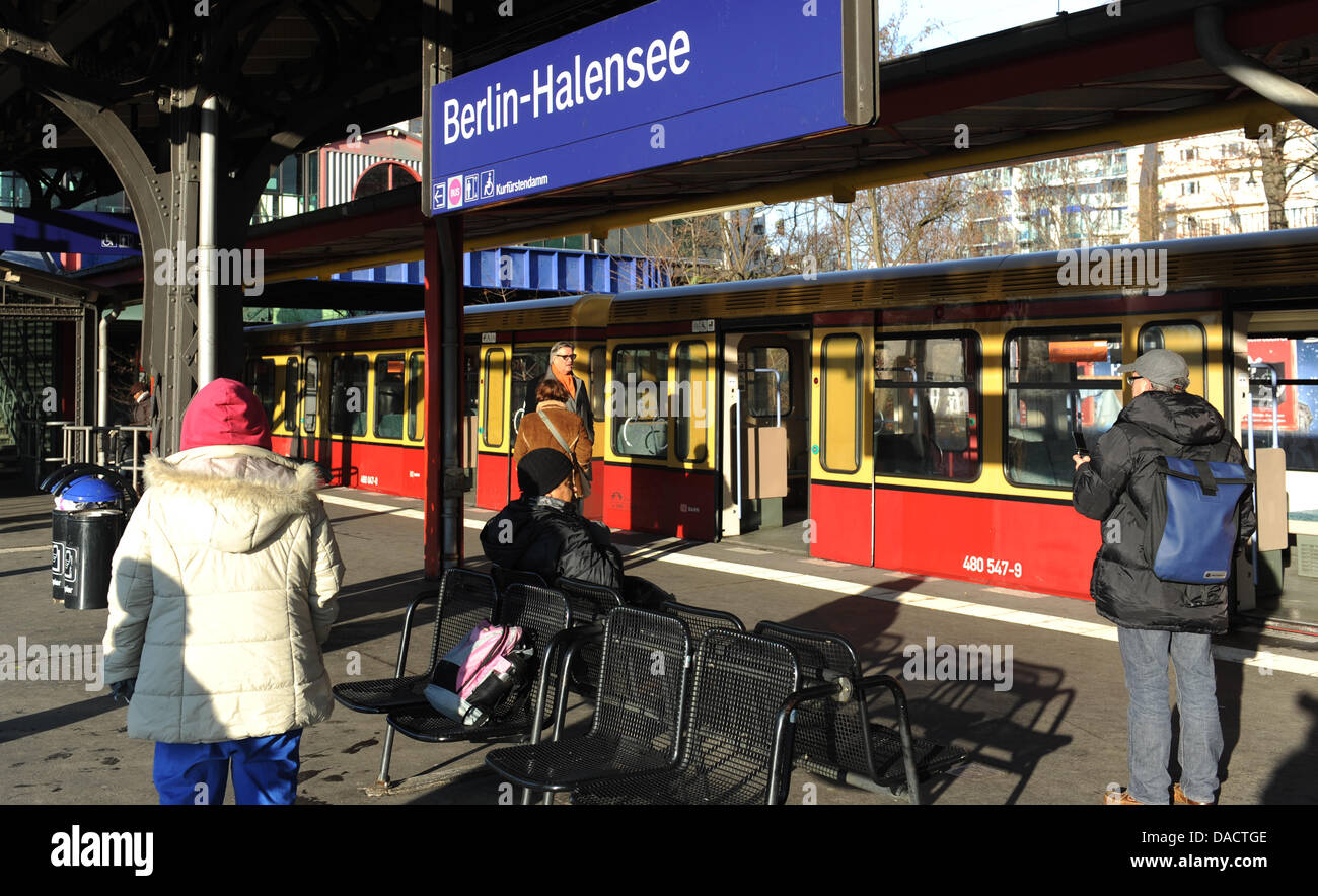 Passengers wait to continue their journey in front of an empty city ...