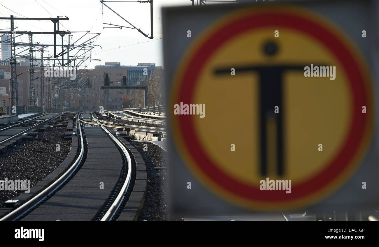 A danger sign is situated in front of empty railway tracks at a ...