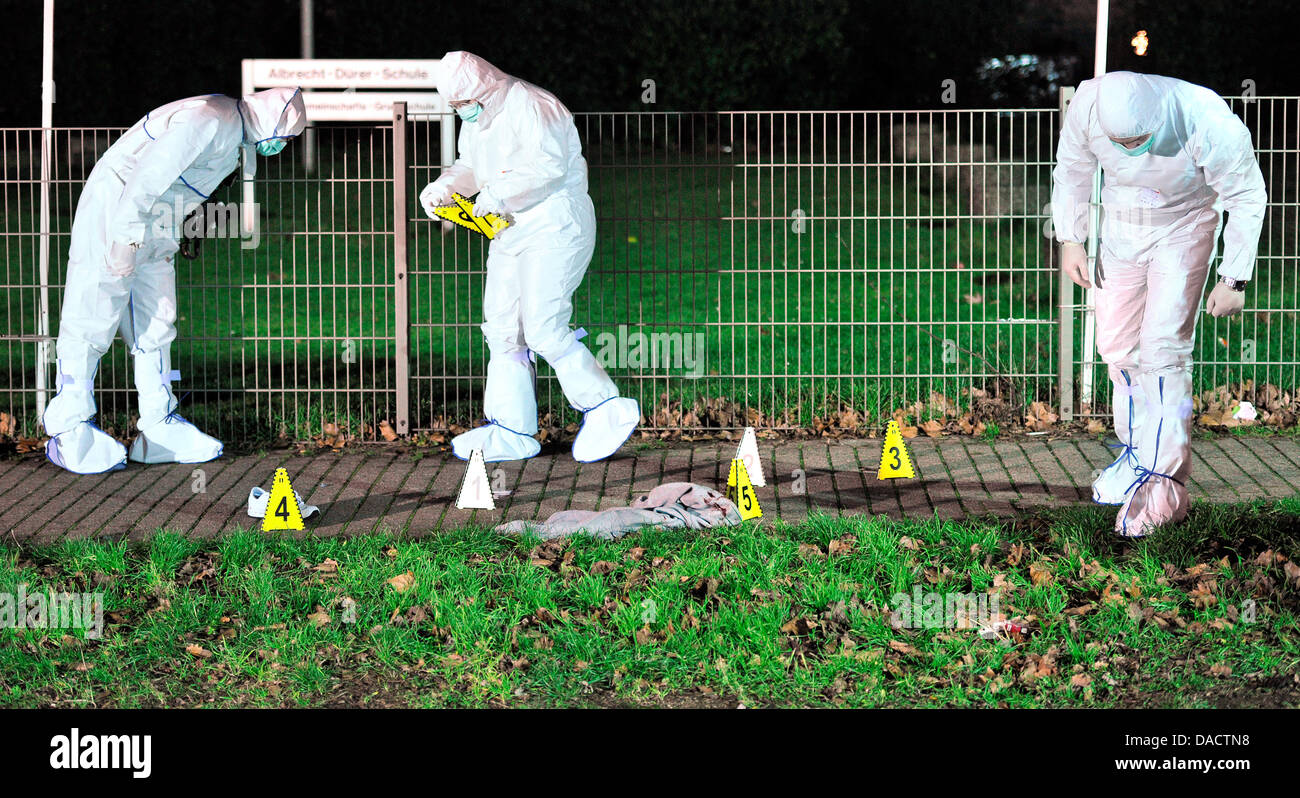 Police officers search and label evidence at a crime scene in Bottrop ...