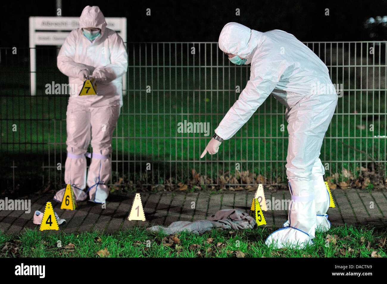 Police officers search and label evidence at a crime scene in Bottrop ...