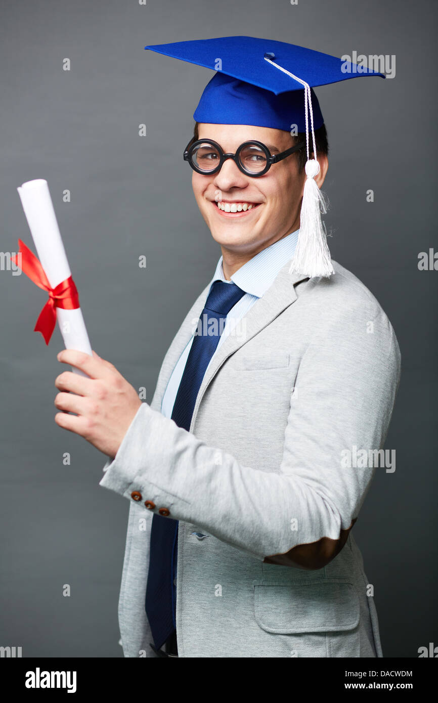 Vertical isolated portrait of a young man wearing a graduation cap and ...