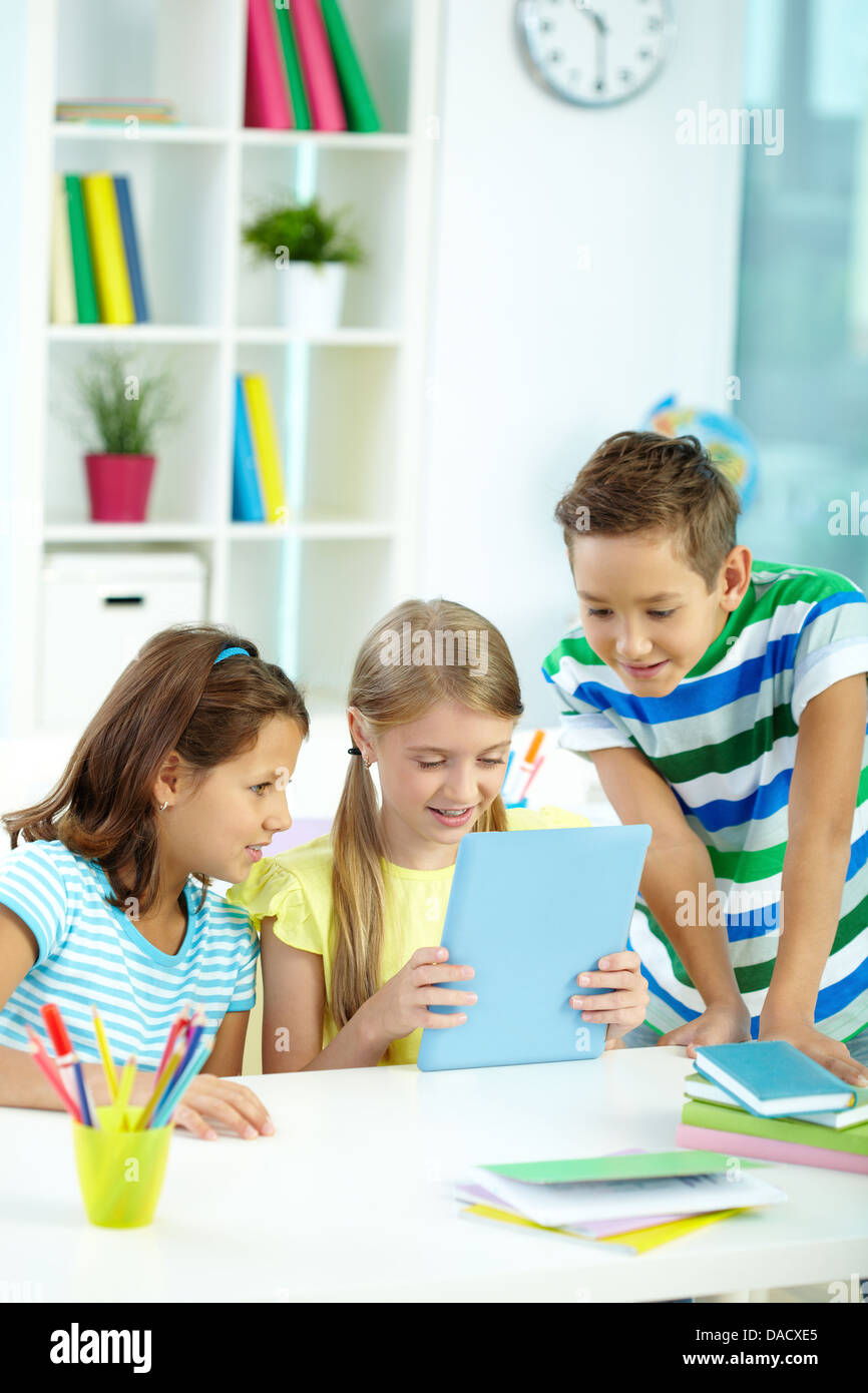 Vertical image of three kids learning how to use a tablet Stock Photo ...