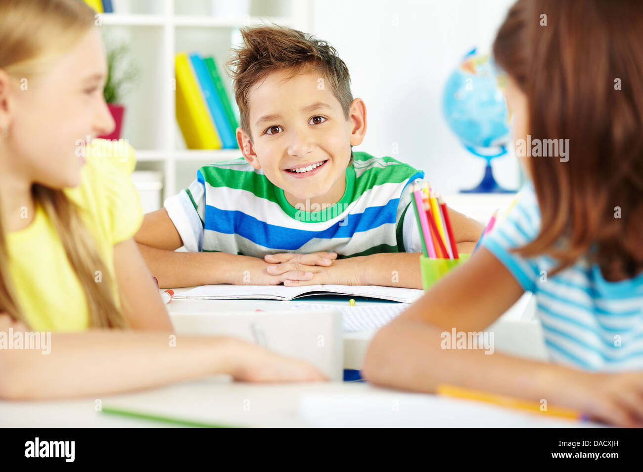 Portrait of a cute school boy smiling in between his classmates Stock ...