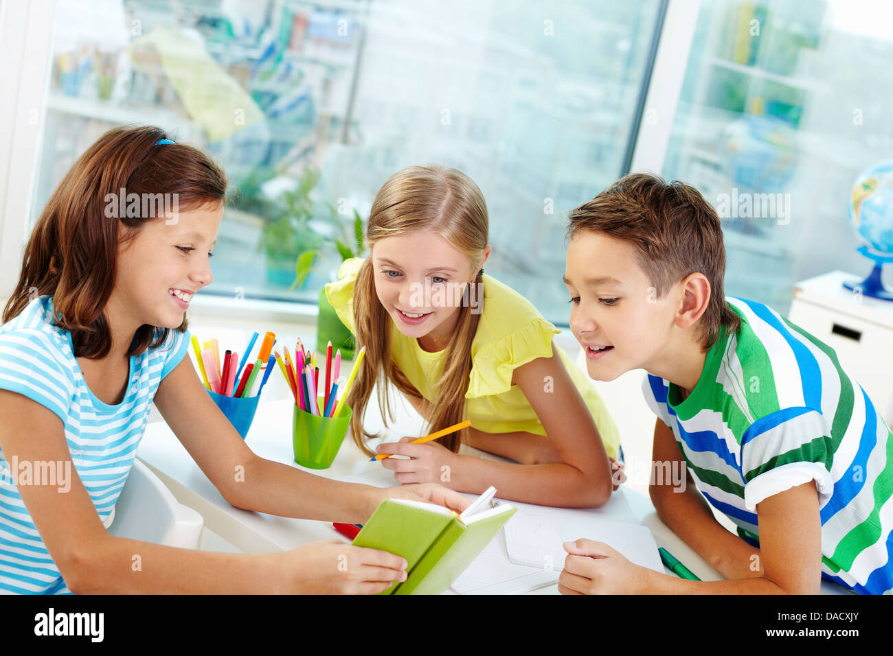 Classmates being curious about what their cute friend reading Stock ...