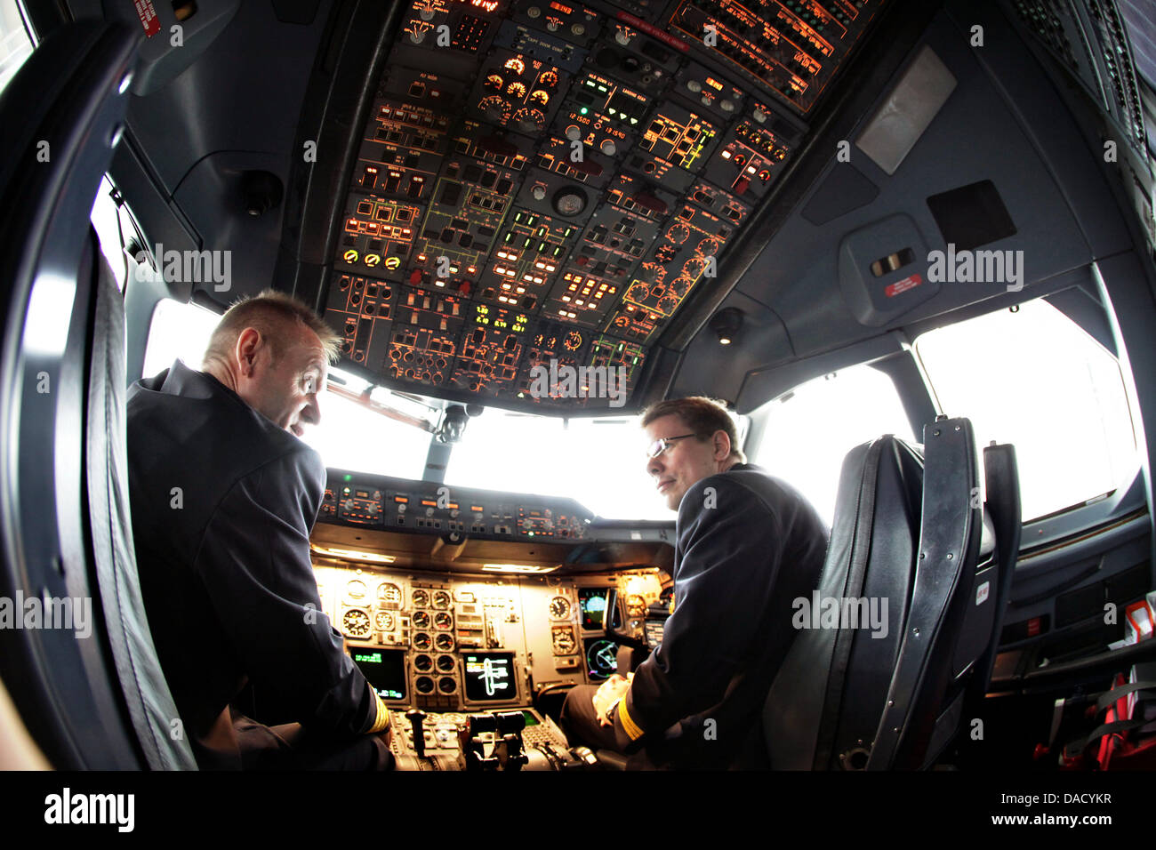 Two pilots discuss details of a flight in a cockpit of a converted ...