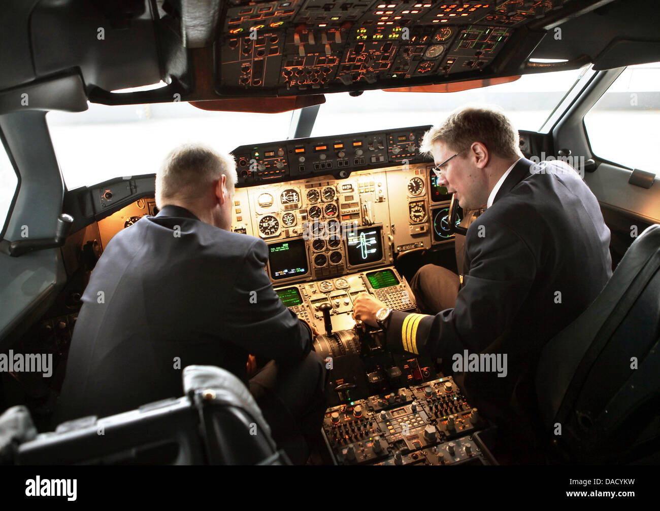 Two pilots discuss details of a flight in a cockpit of a converted ...