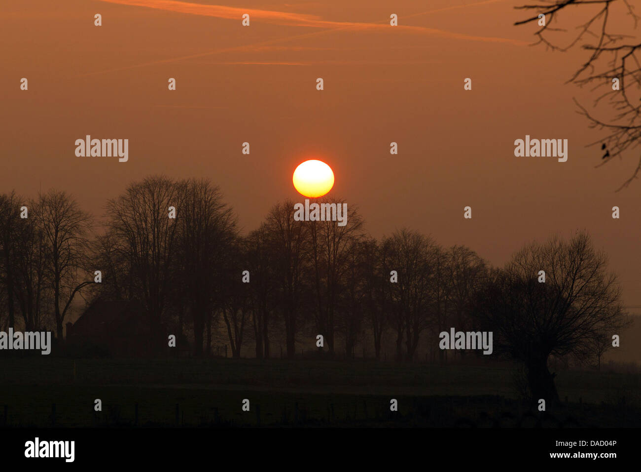 The sky is lit up red at sunset above Gallin farm in Gallin, Germany ...