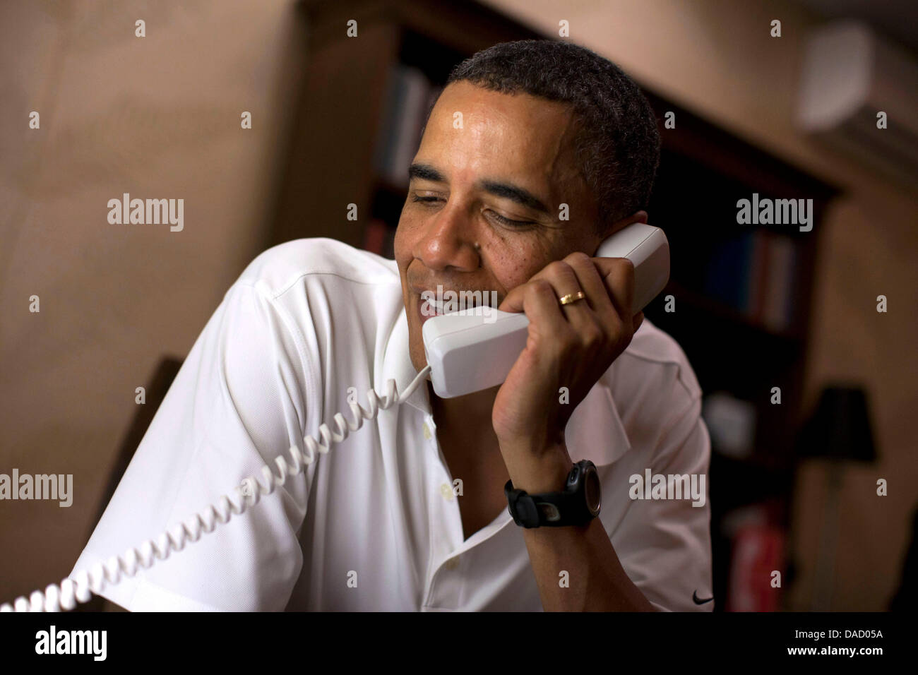 United States President Barack Obama reacts while talking on the phone ...