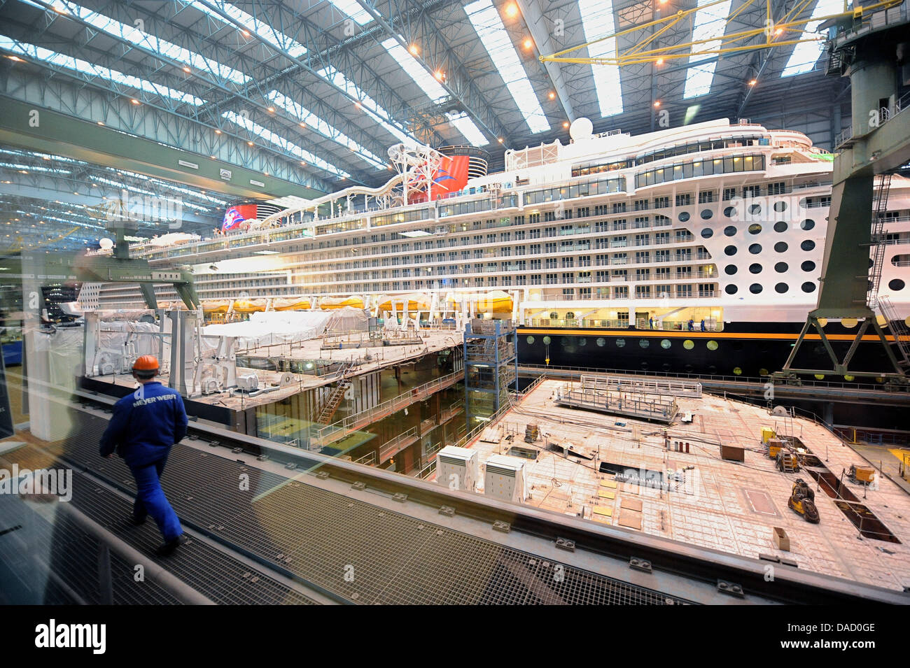 A worker at the Meyer shipyard walks along the cruise liner 'Disney ...