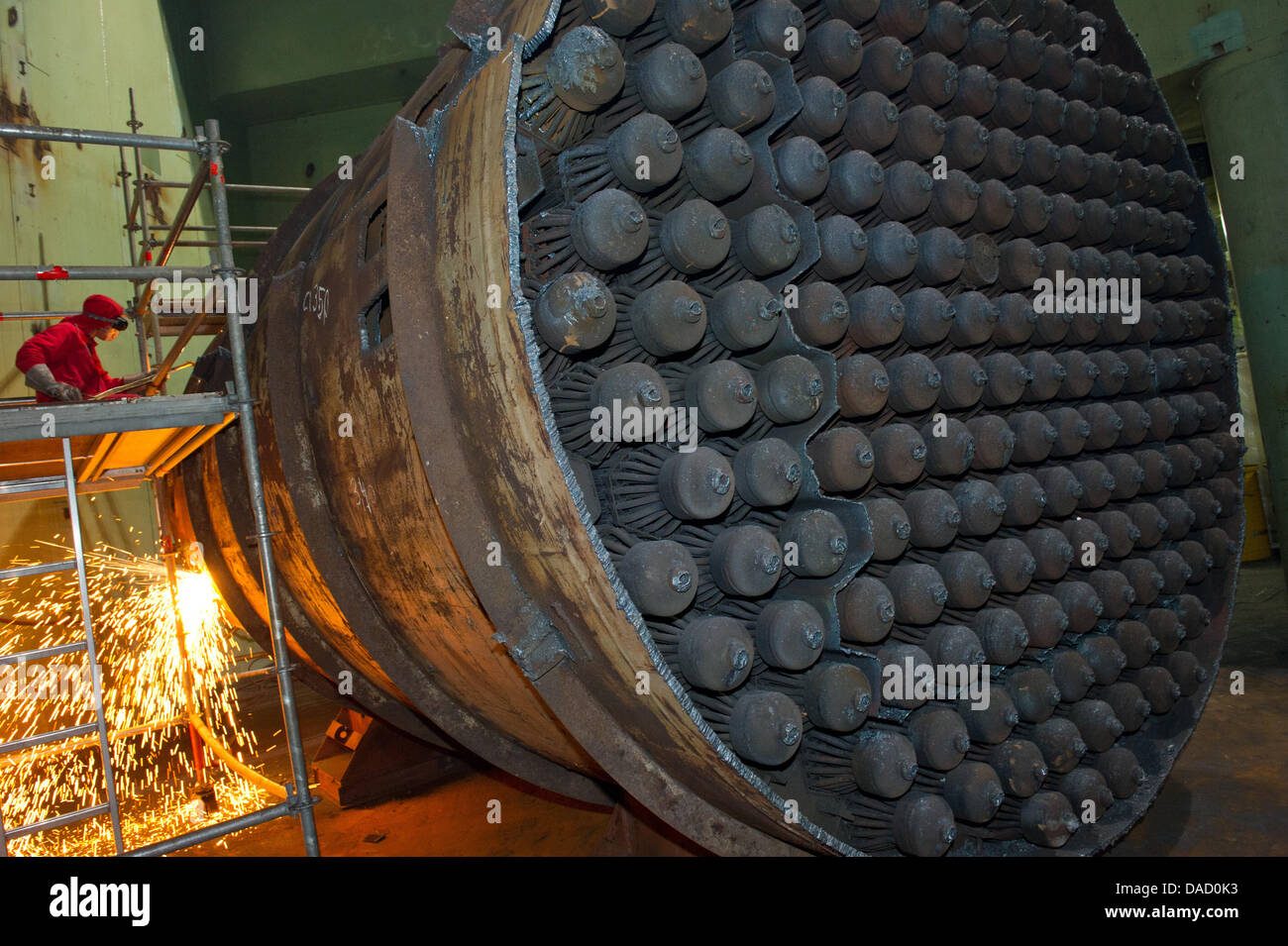 A worker dismantles an extremely heavy reheater at a dismantling site ...