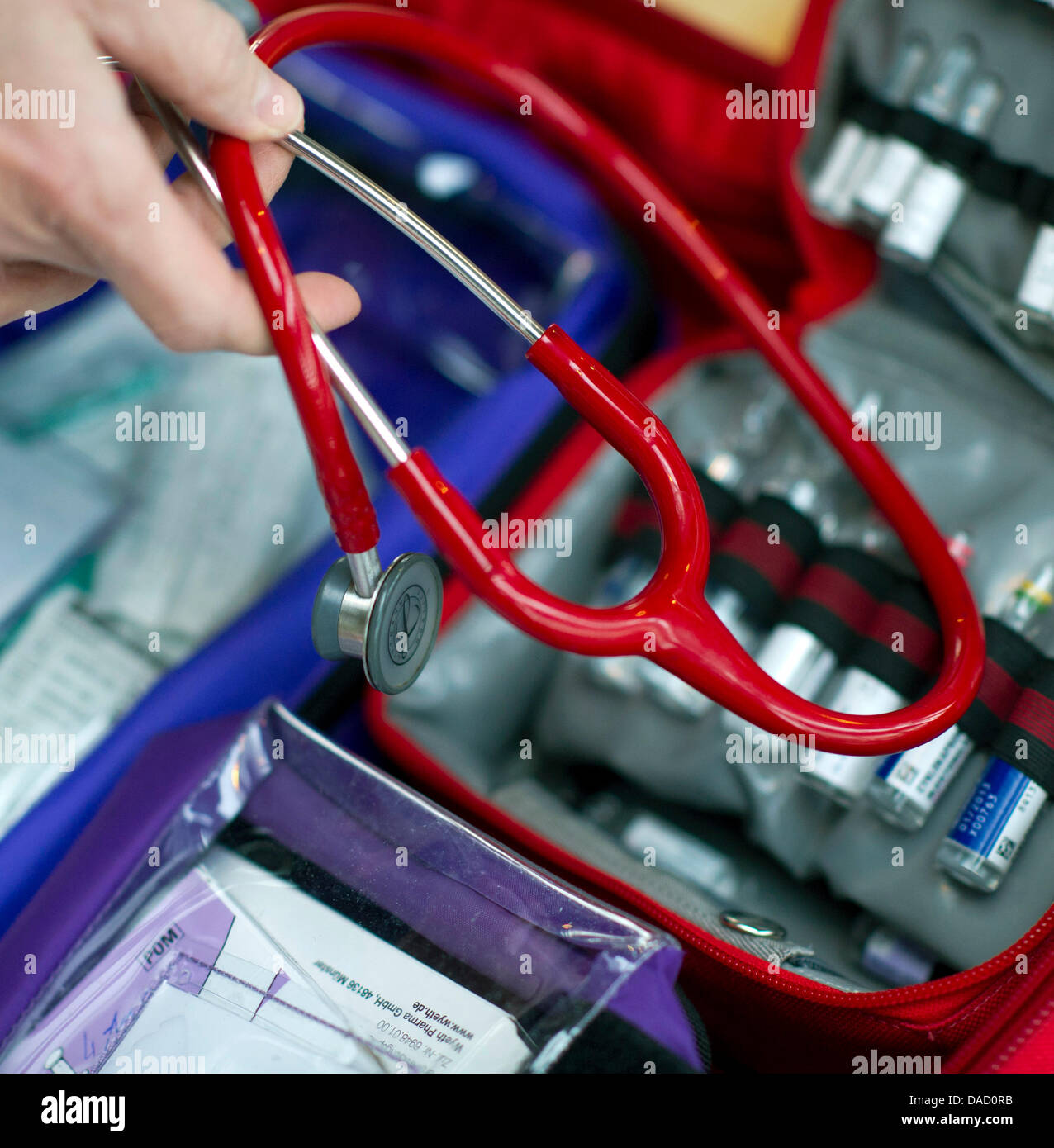 A doctor takes a stethoscope out of an emergency tool kit at the ...