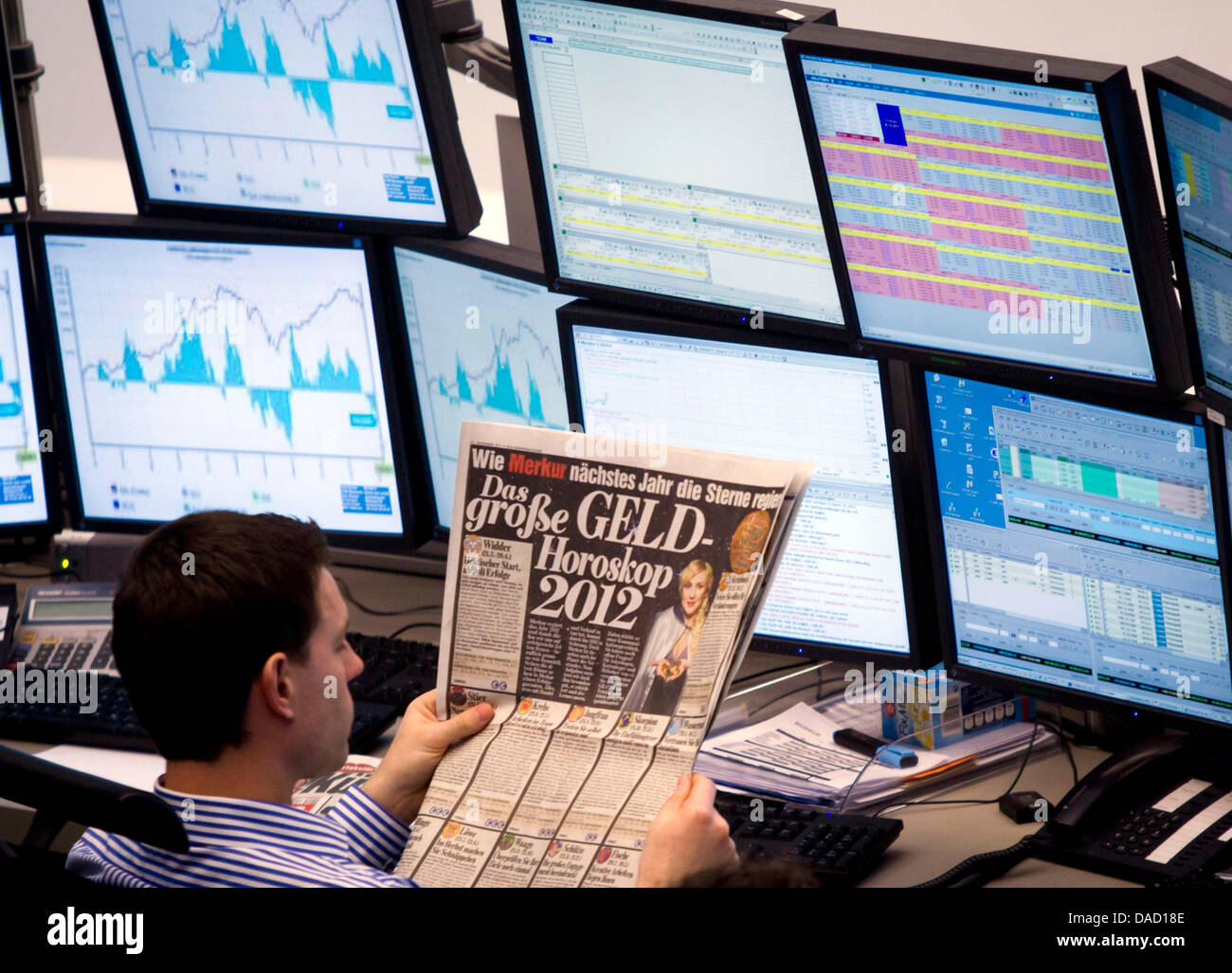 A trader reads a newspaper during a short break at the Frankfurt Stock ...