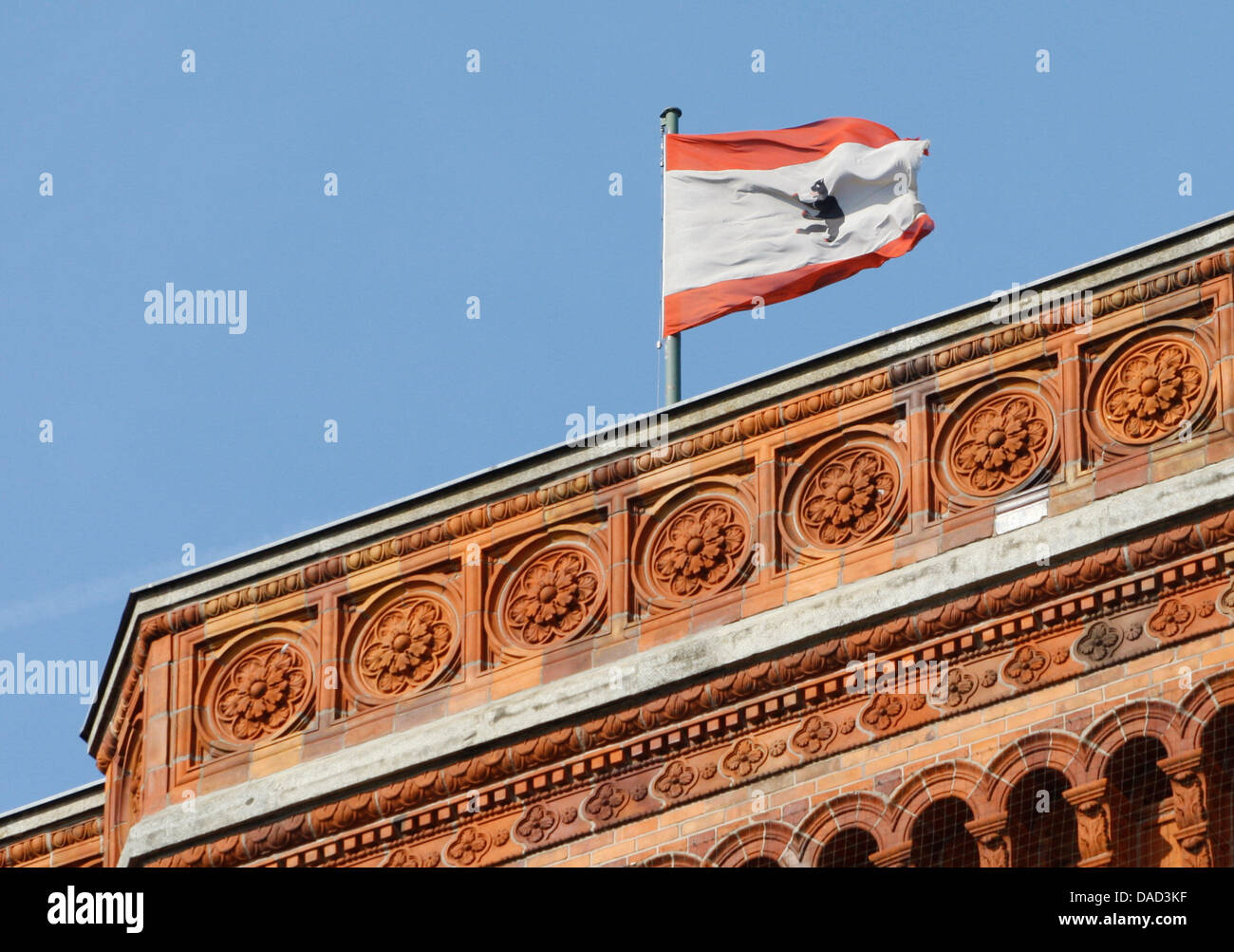 The Berlin flag flies in front of a blue sky atop the Red City Hall ...