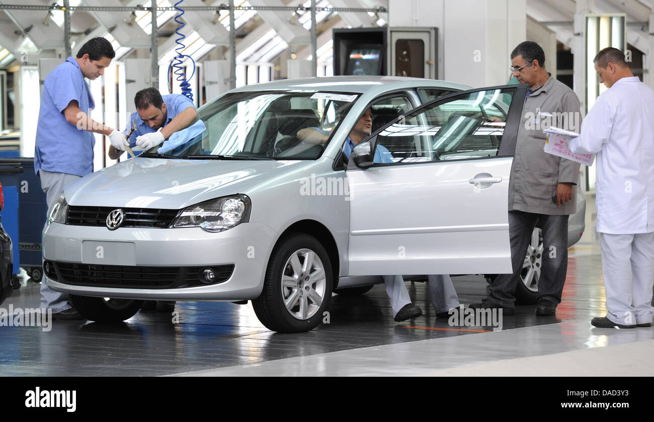 Workers finalise the assembly of a new VW car model on the assembly ...