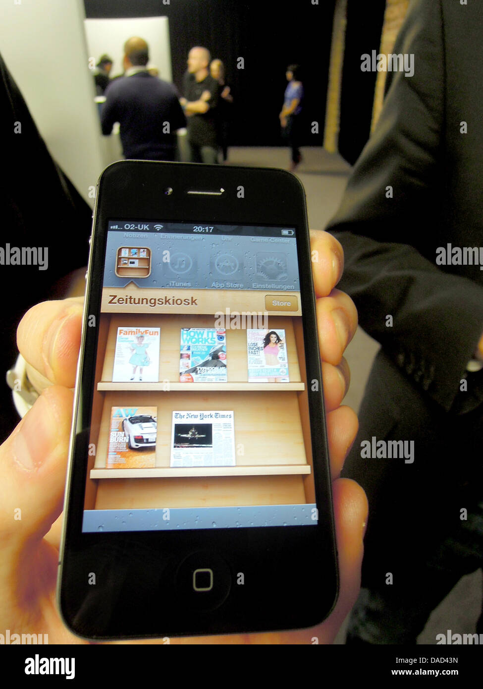 A journalist holds the new iPhone 4S of Apple in his hands at a ...