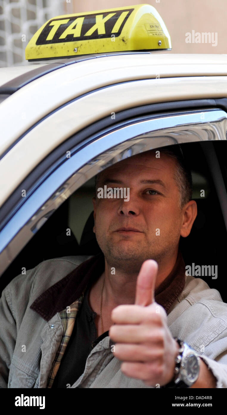 Cab driver Stefan Uhrich gives the viewer a thumbs-up in Munich ...
