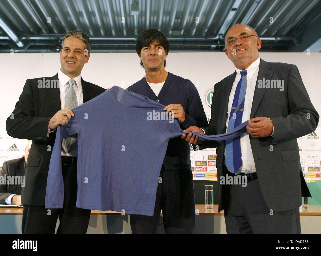 German national coach Joachim Loew (C) hands over his blue pullover to ...