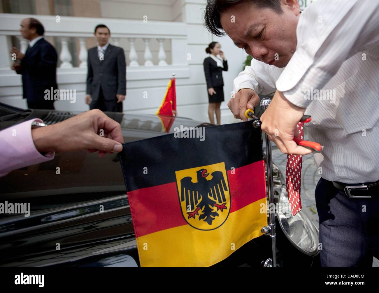 A driver tries to attach the German flag to the car of German ...