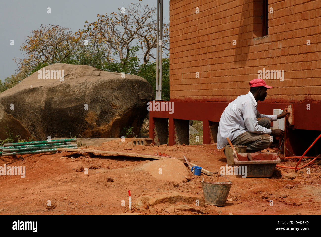 A construction worker paints a wall at the opera village near the ...