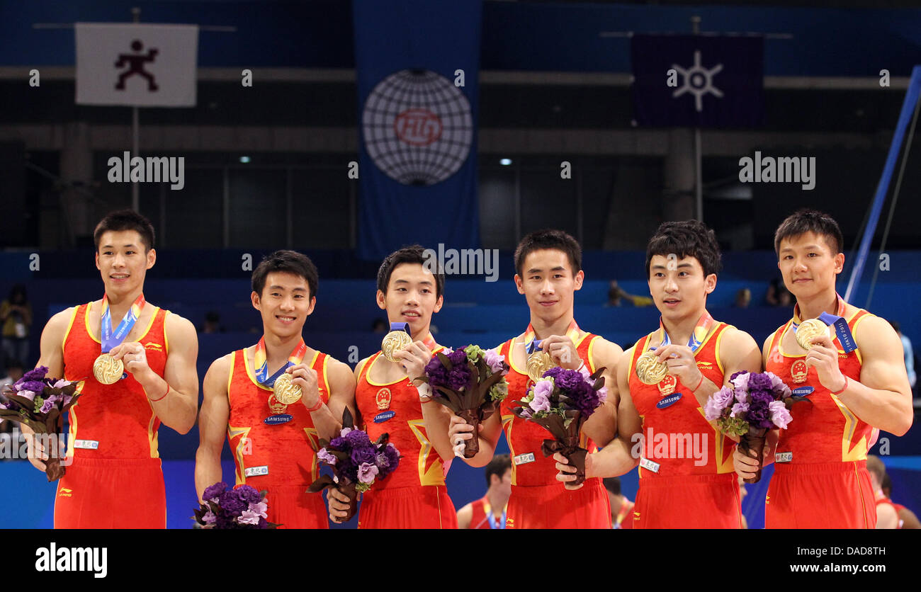 Chinese gymnasts pose with their gold medals on the podium after ...